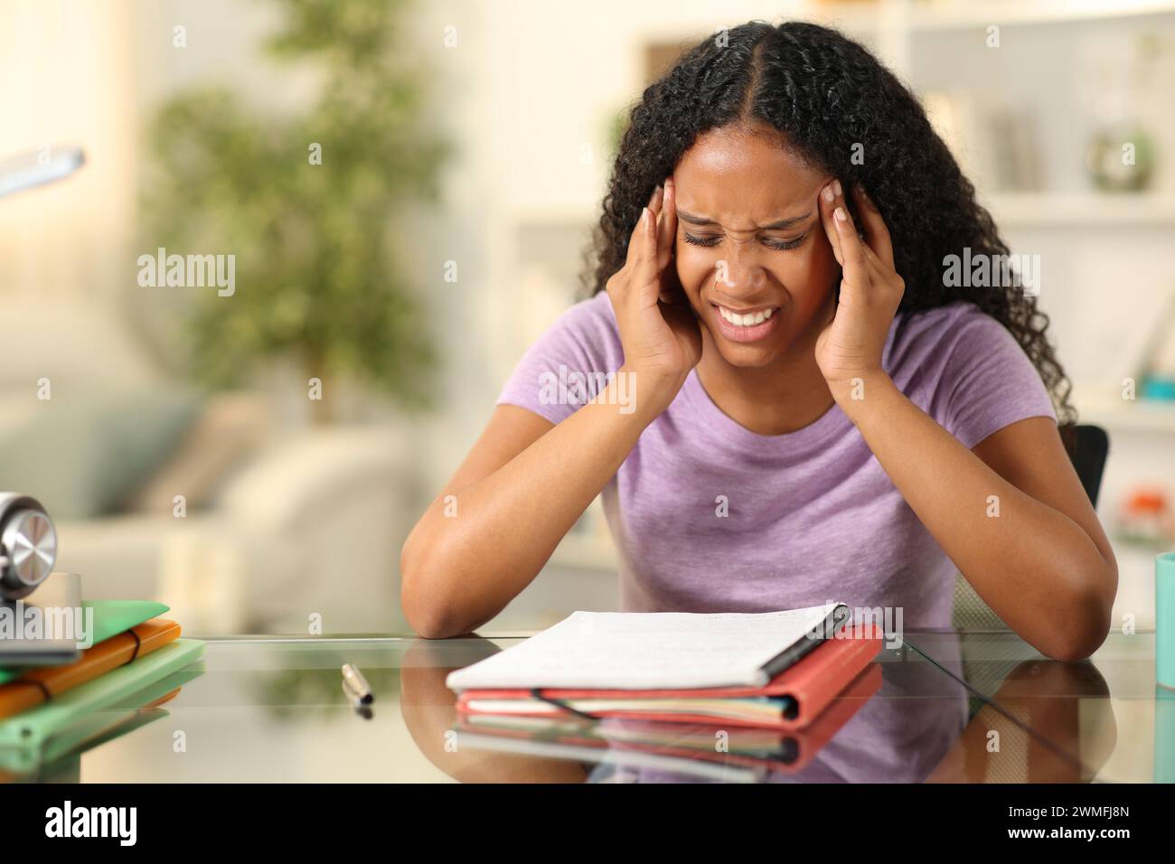 Stressed black student suffering head ache while studying at home Stock ...