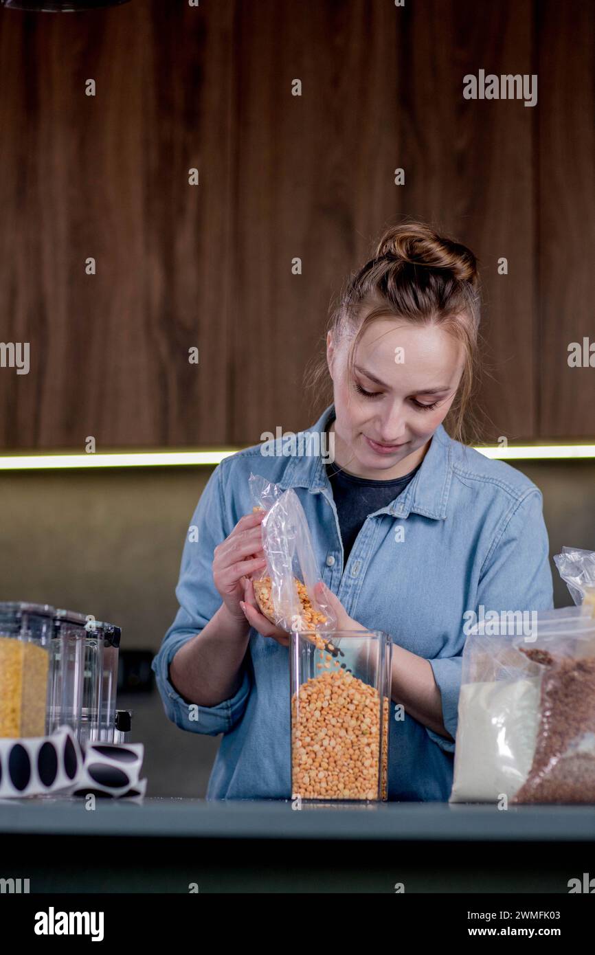 Woman organizing food in the kitchen with containers Stock Photo - Alamy