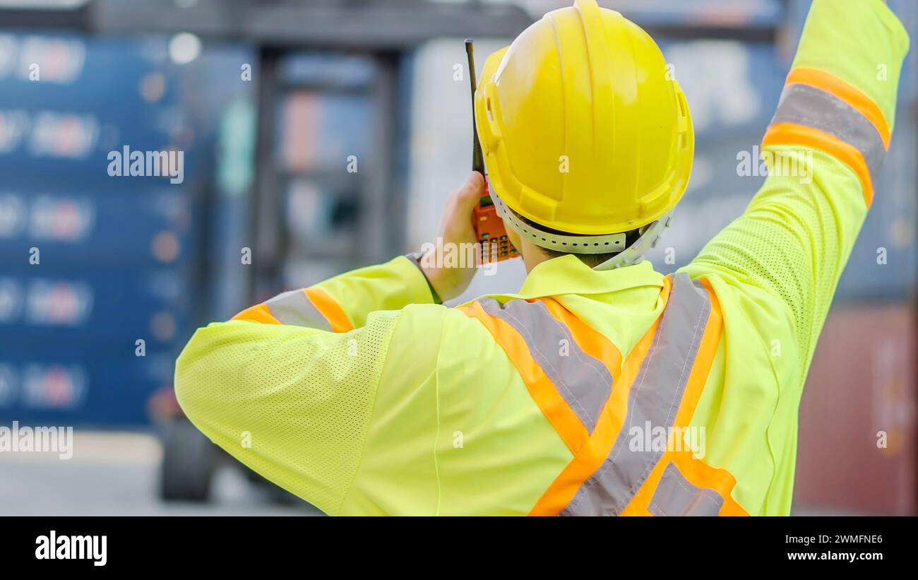 A dock foreman with a radio standing against the background of cargo ...
