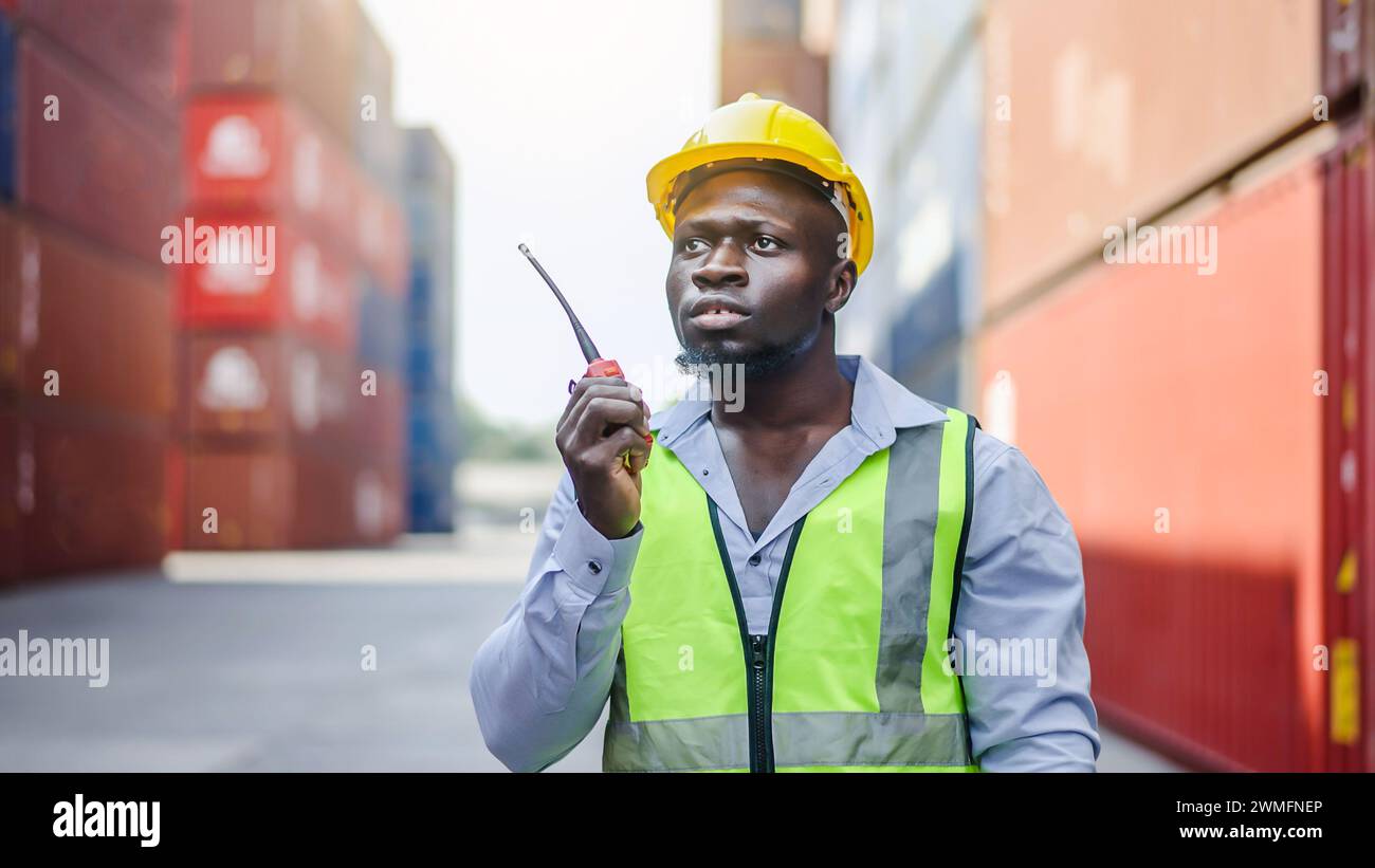 A dock foreman with a radio standing in front of cargo containers Stock ...