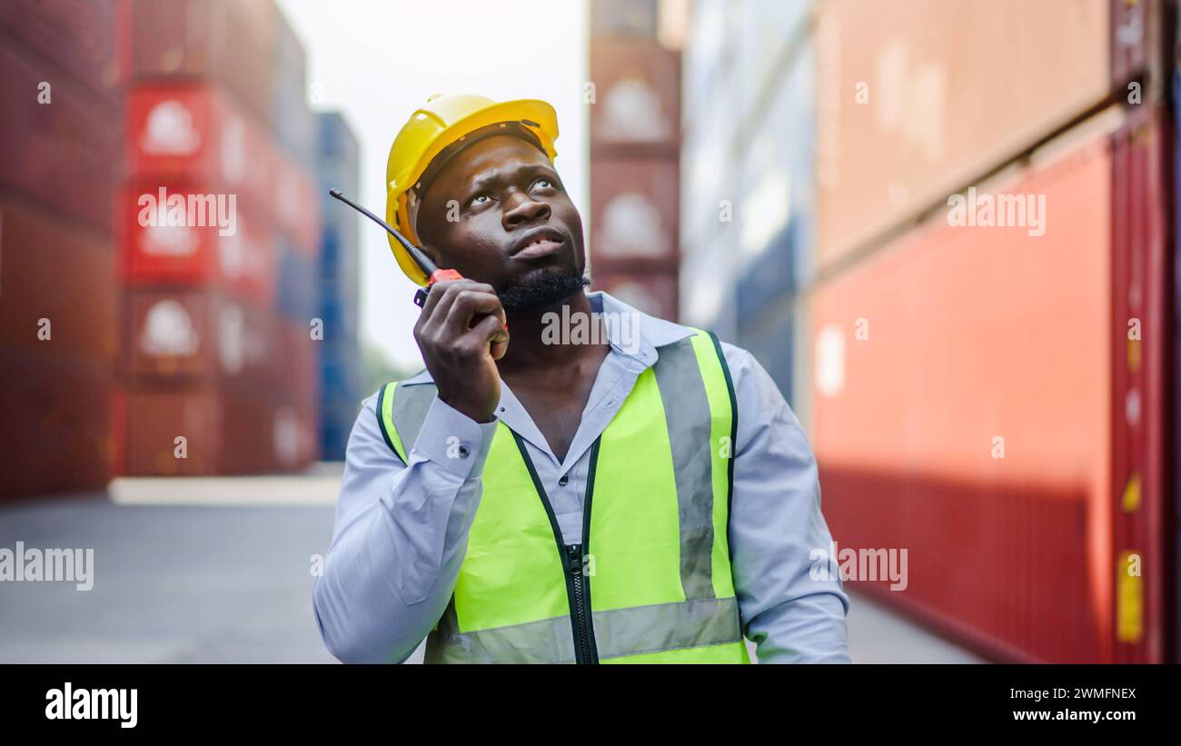 A dock foreman with a radio standing in front of cargo containers Stock ...