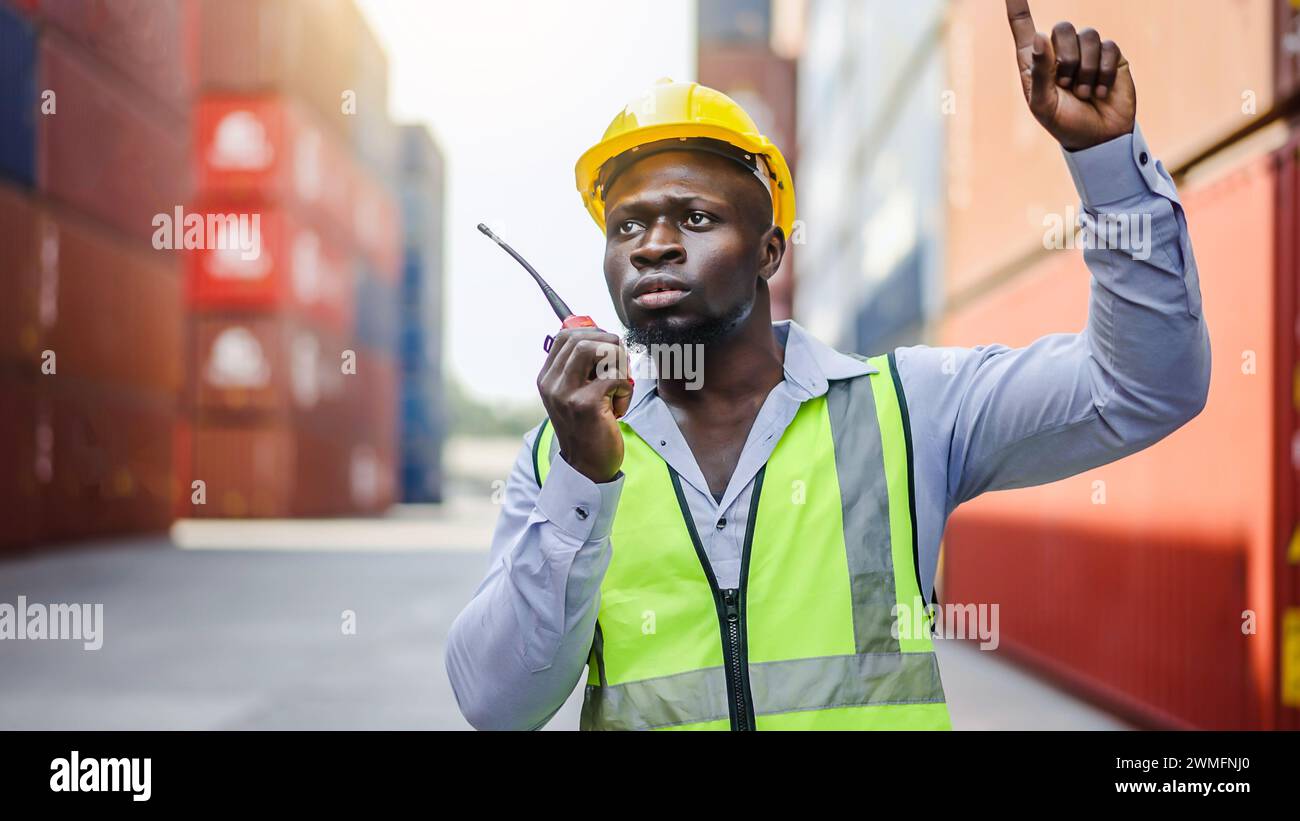 A dock foreman with a radio standing in front of cargo containers Stock ...