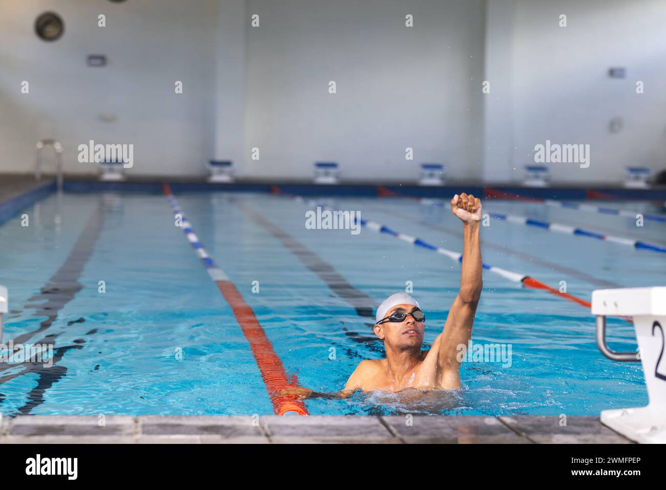 A swimmer reaches the end of the pool in an indoor facility. The ...