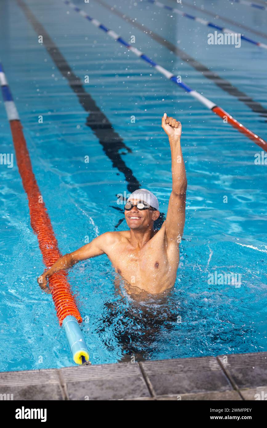 Young biracial male athlete swimmer celebrates victory in a swimming ...