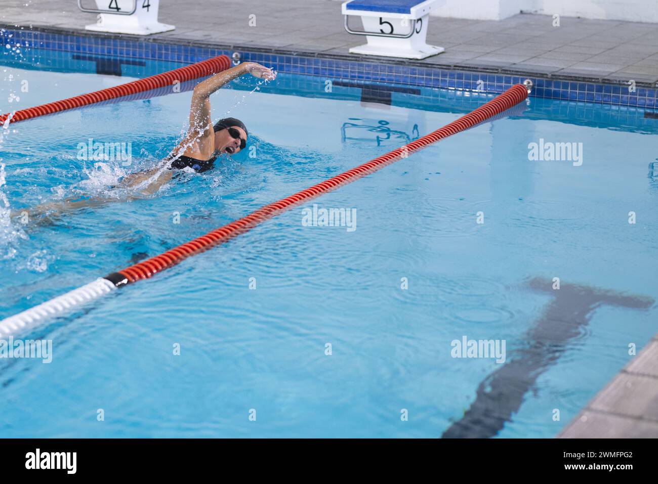 Caucasian female athlete swimmer swims in an indoor pool Stock Photo ...