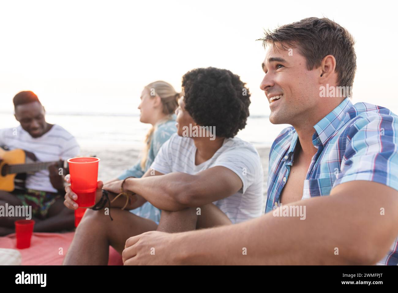 Diverse friends enjoy a beach gathering Stock Photo - Alamy