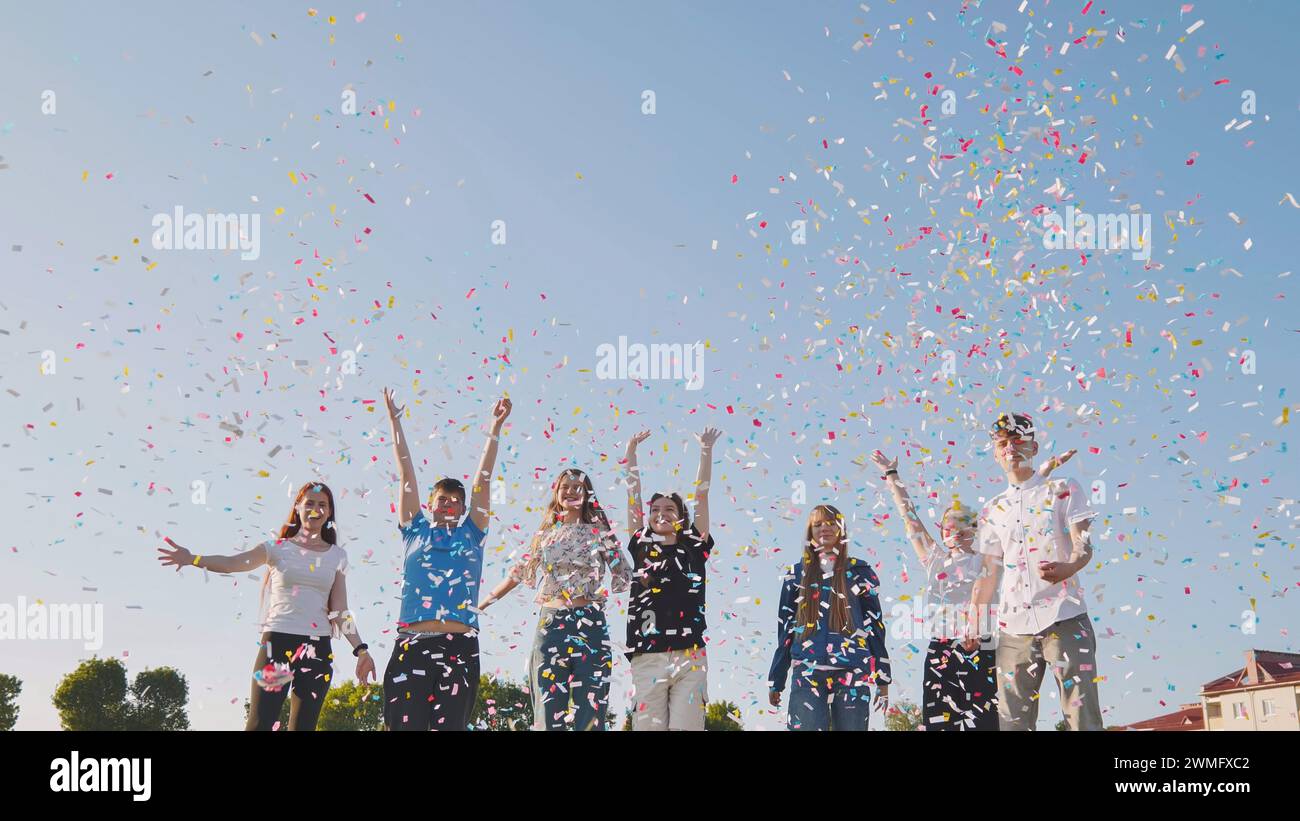 Friends toss colorful paper confetti from their hands Stock Photo - Alamy