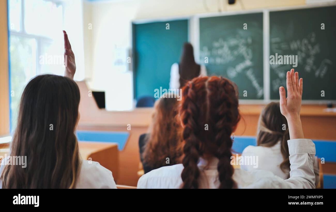 Girl students raise their hands in math class Stock Photo - Alamy