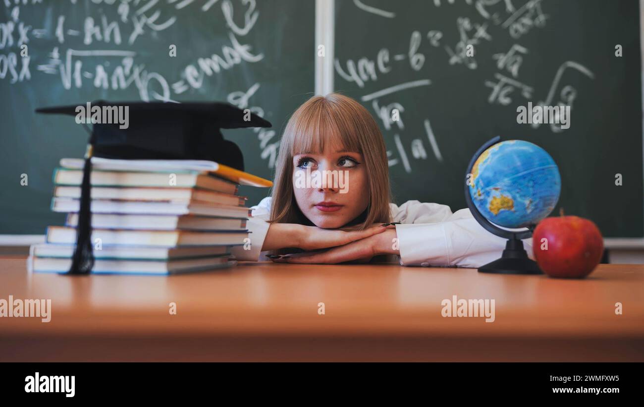 Blonde schoolgirl with bangs poses in front of school objects Stock ...