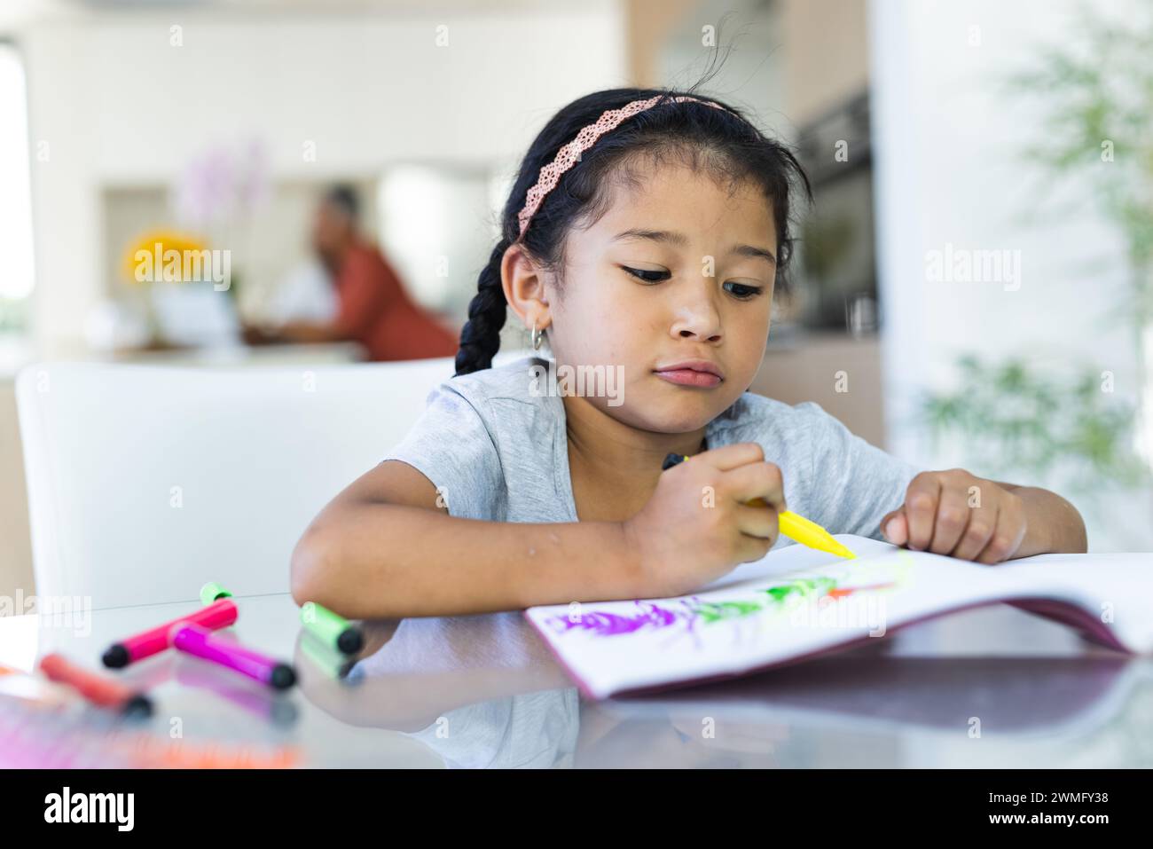 A Biracial Girl Focuses On Coloring At Home With Copy Space Stock