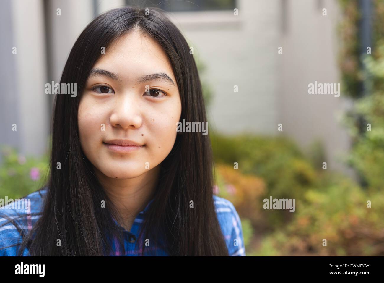 A teenage Asian girl smiles gently outdoors with copy space Stock Photo ...