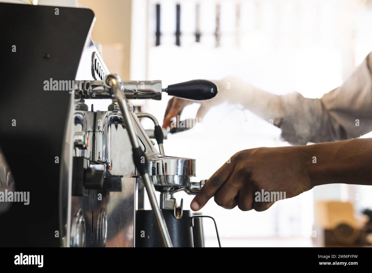 African American barista operates an espresso machine at a cafe Stock ...