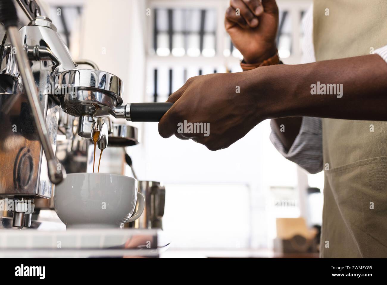 An African American barista prepares espresso at a coffee machine Stock ...