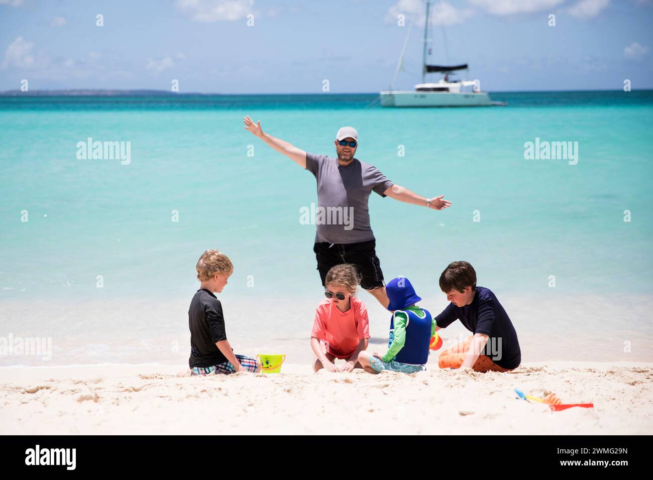 Silly Dad Stands Behind Four Kids on Caribbean Beach Stock Photo - Alamy