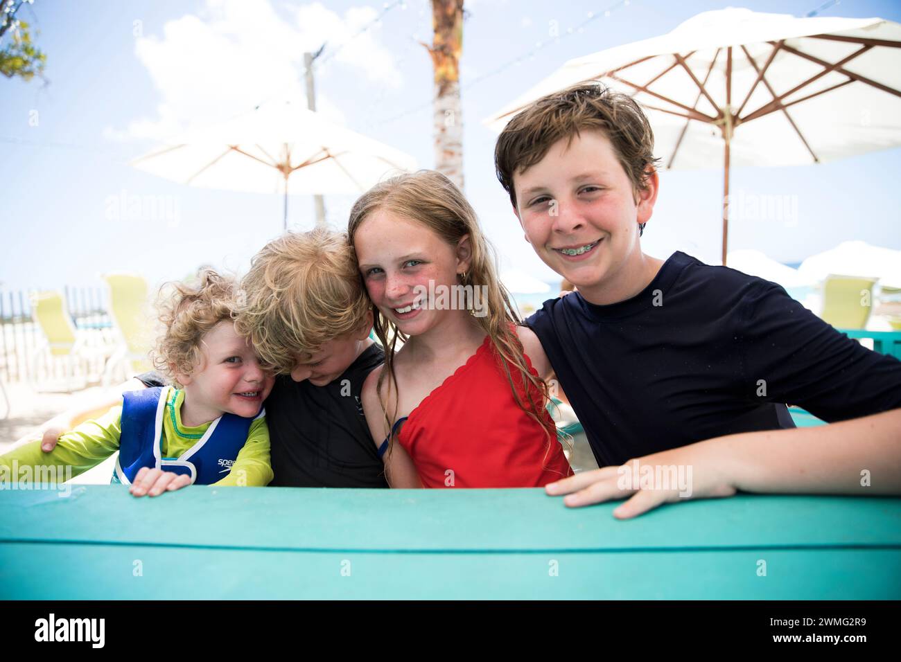 Four Siblings Sit Together on Vacation at Colorful Picnic Table Stock ...