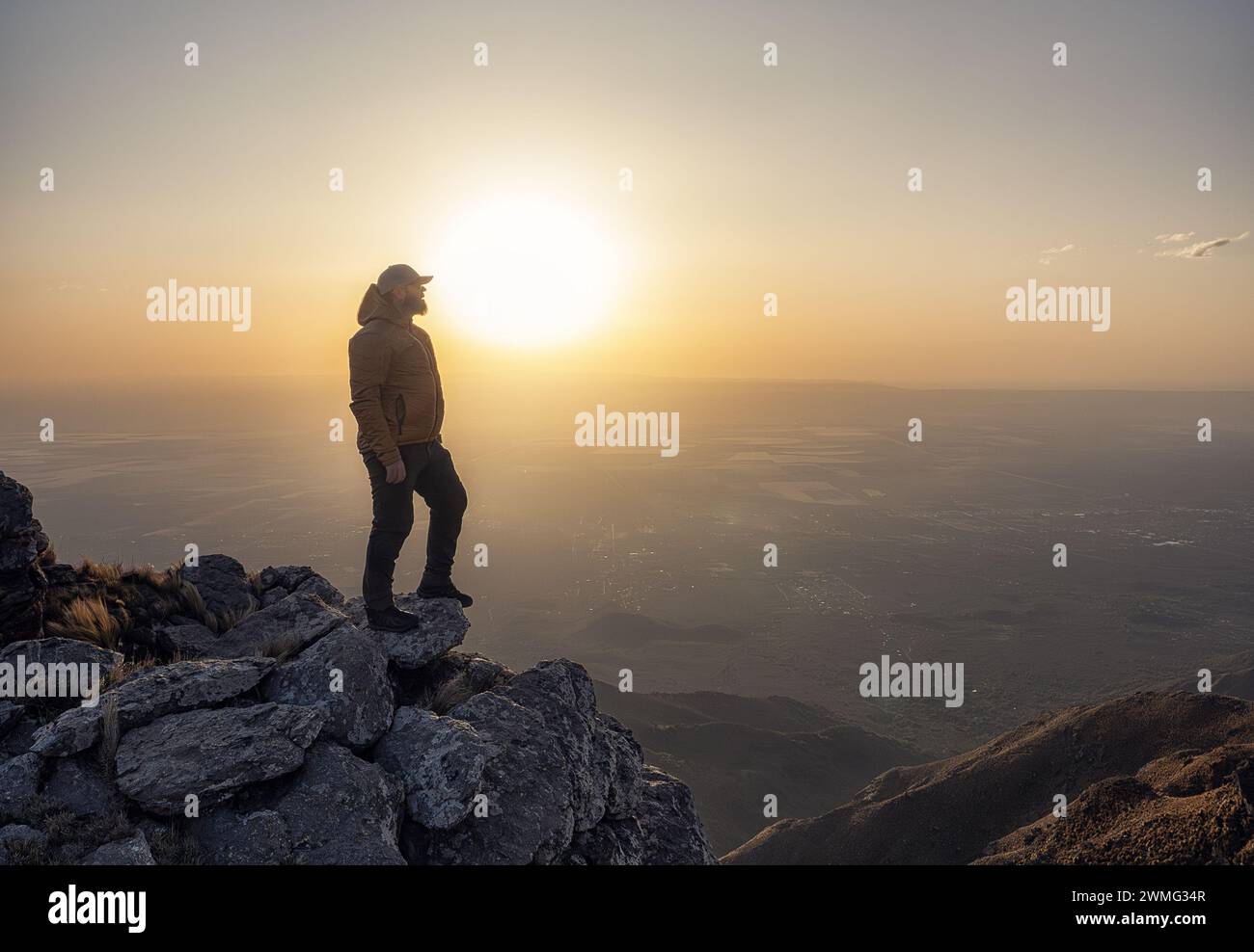 man posing on top of a mountain at sunset Stock Photo - Alamy