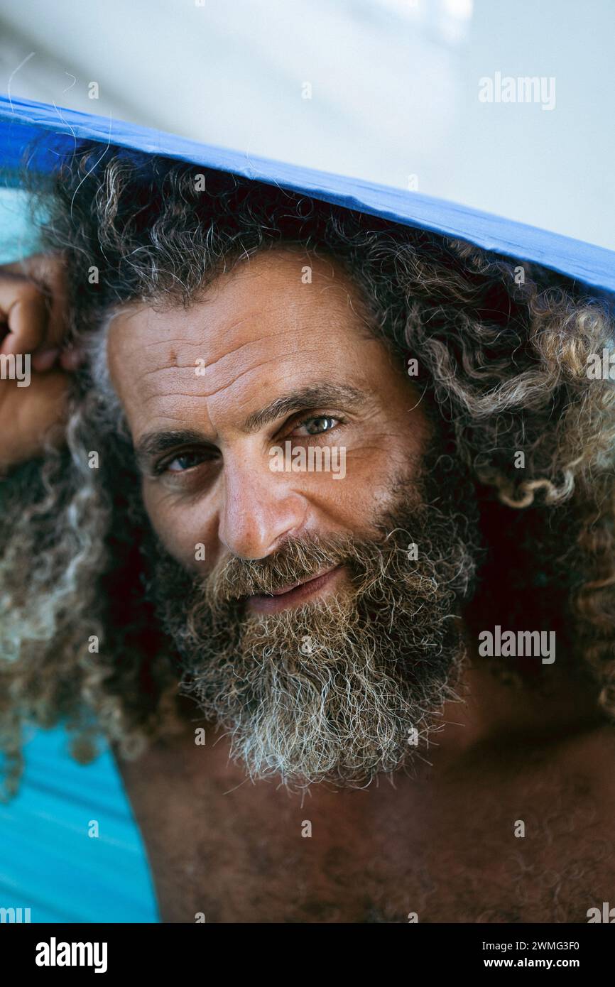 Arabic palestinian man with long curly hair is resting in a hammock ...