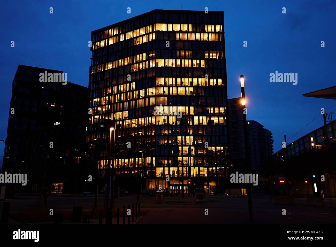 Office building lights up the evening with windows glowing in the dusk ...