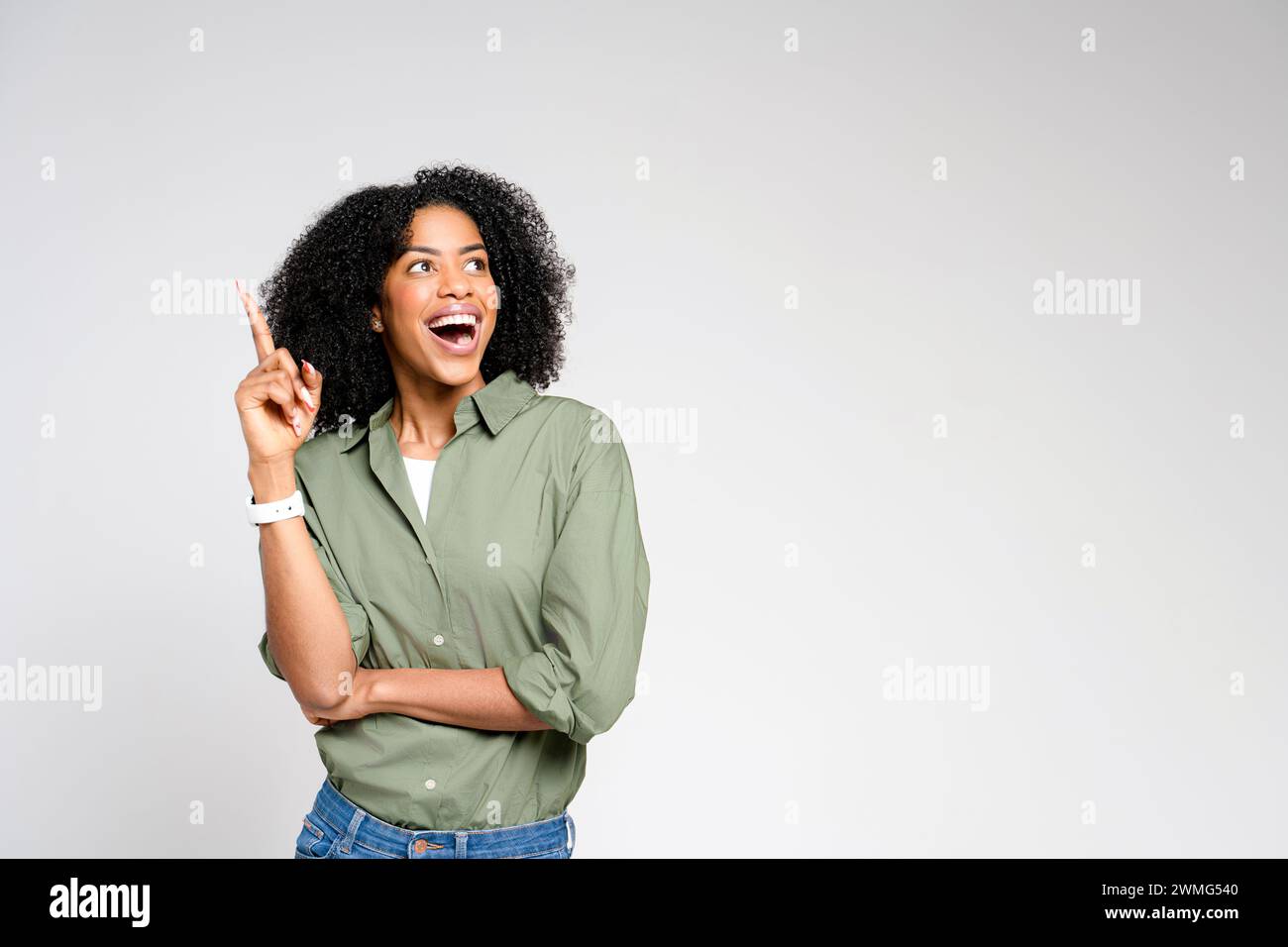 Radiating joy, an African-American woman points upwards, her face ...