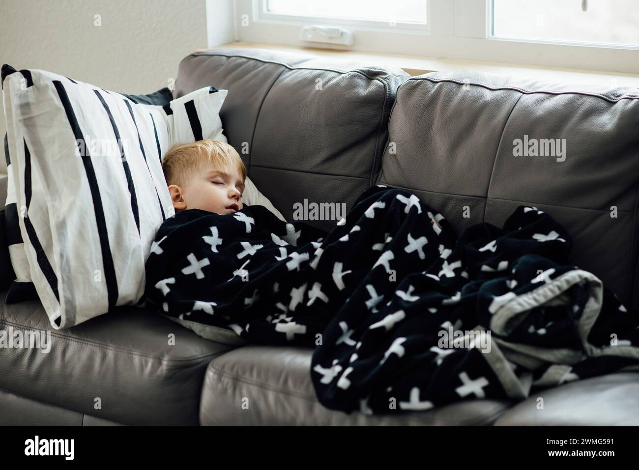 Side view of young boy sleeping on couch in daylight Stock Photo - Alamy