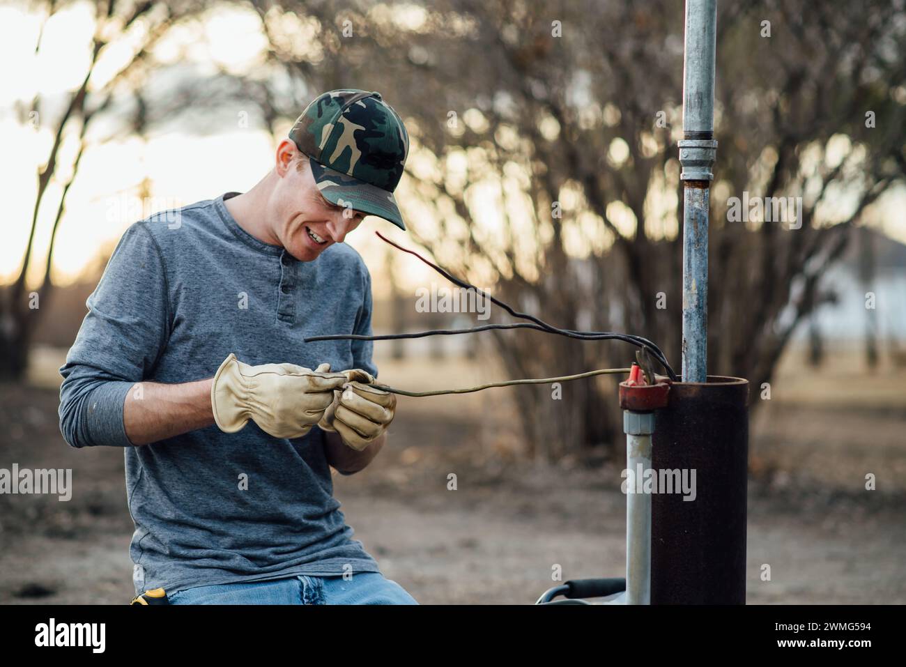 Close up of man smiling while doing electrical work outside Stock Photo ...
