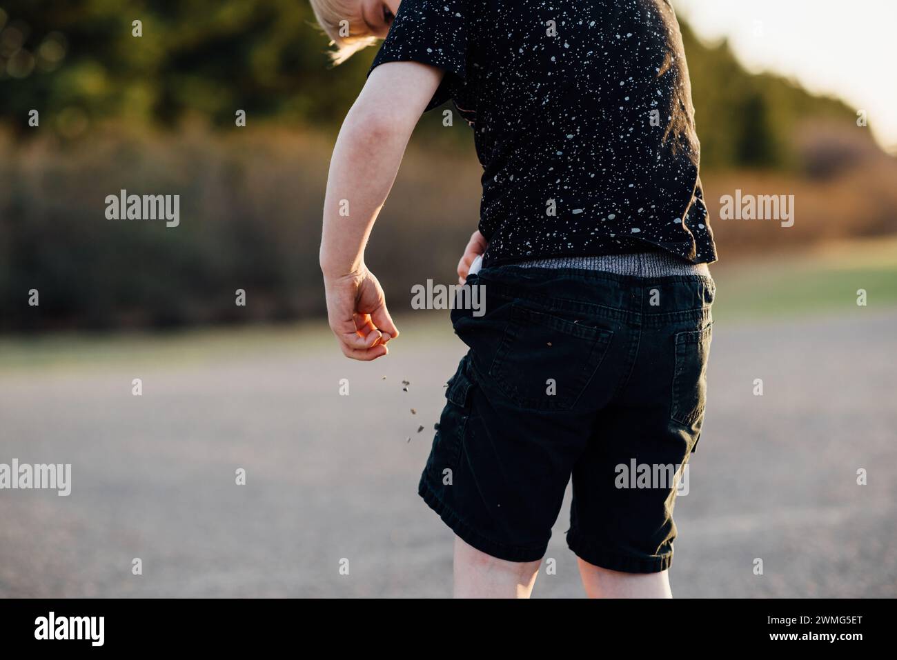 Close up rear view of young child putting rocks in pocket Stock Photo ...