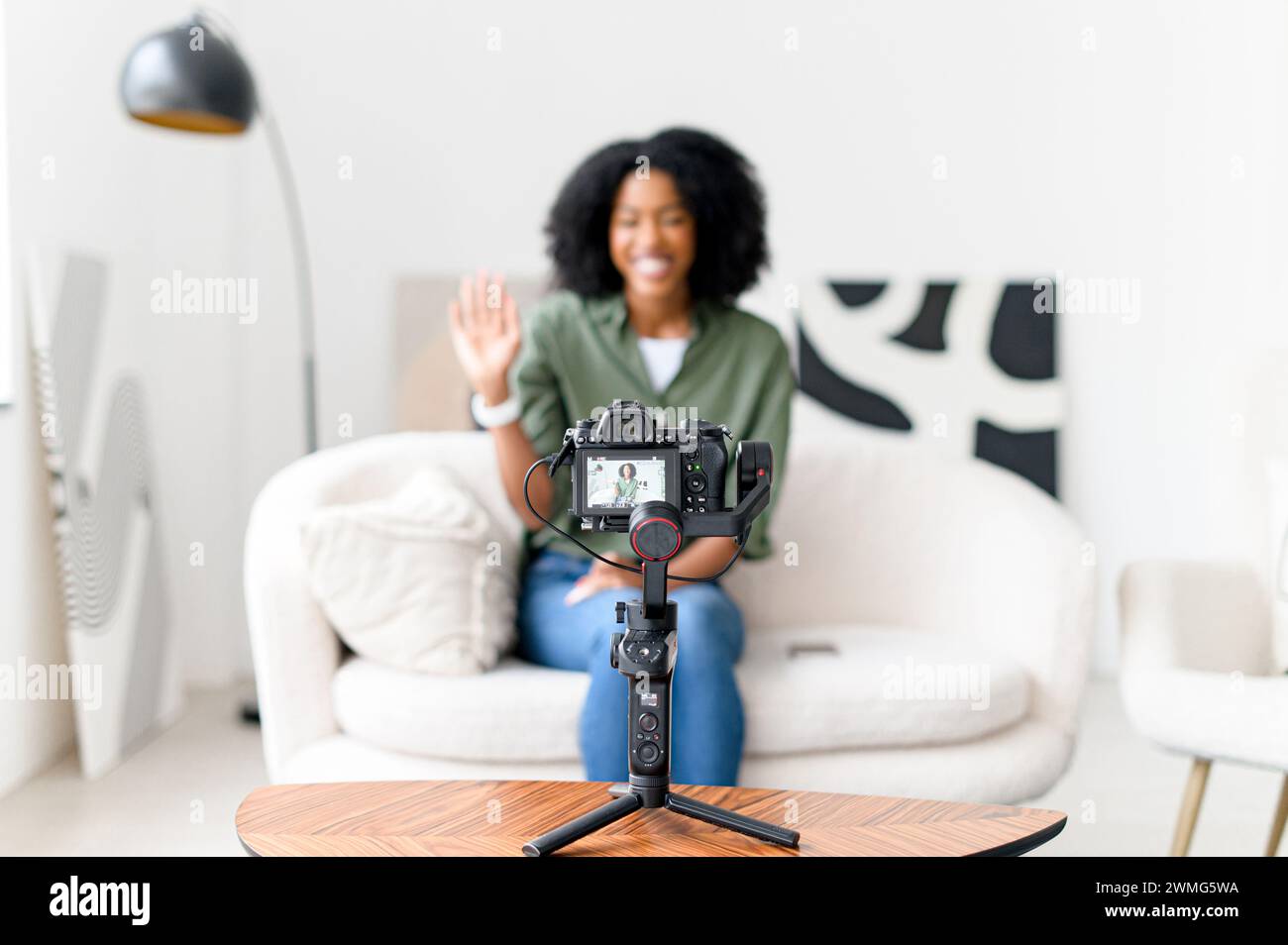 A vivacious African-American vlogger warmly greets her online community ...