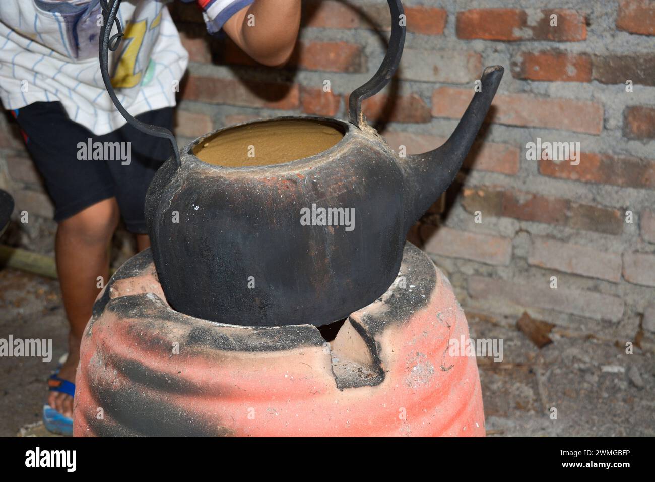 Still life typical Indonesian traditional teapot. Against a red brick ...