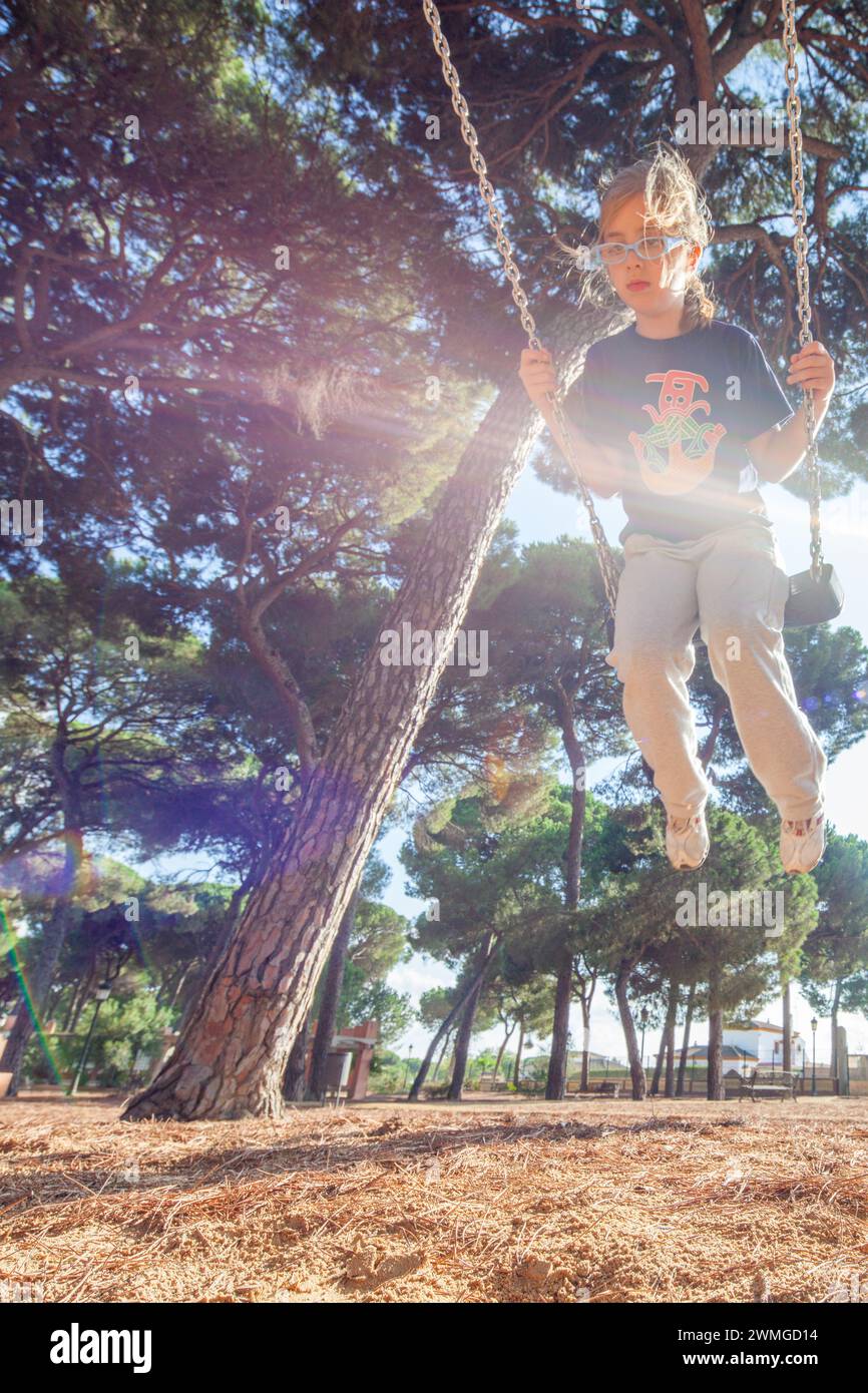 A child enjoys a swing set surrounded by pine trees in Hinojos, Spain ...