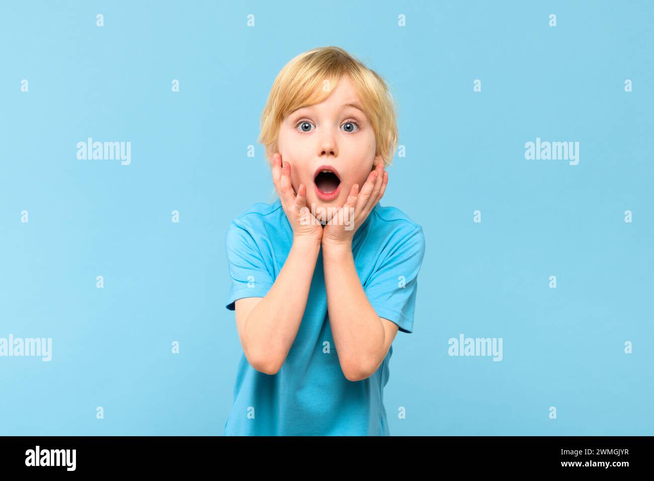 Wow! Portrait of a shocked cute little boy with blond hair on pastel ...