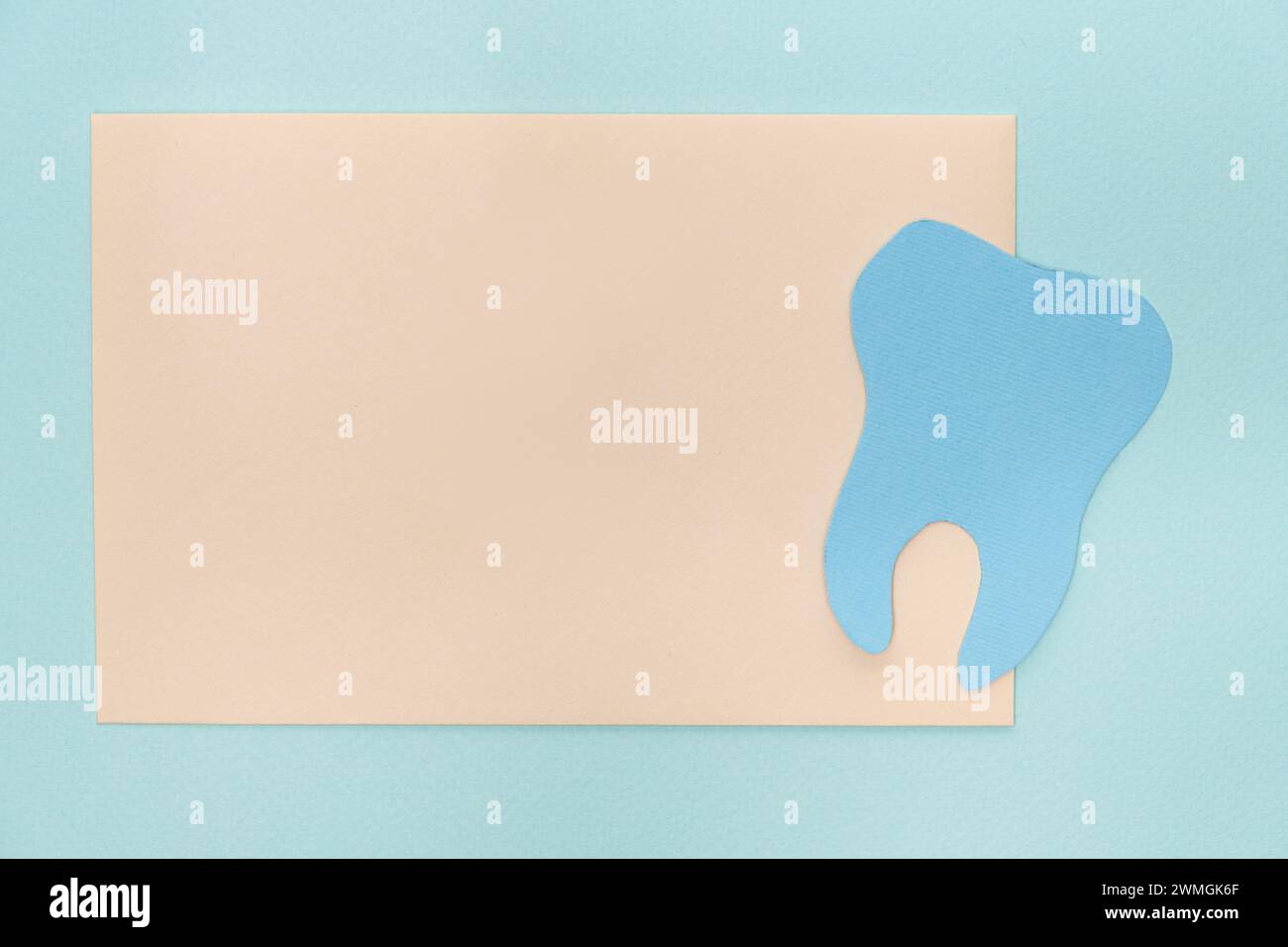 Dental greeting card. Paper tooth on a blue and beige background, space ...