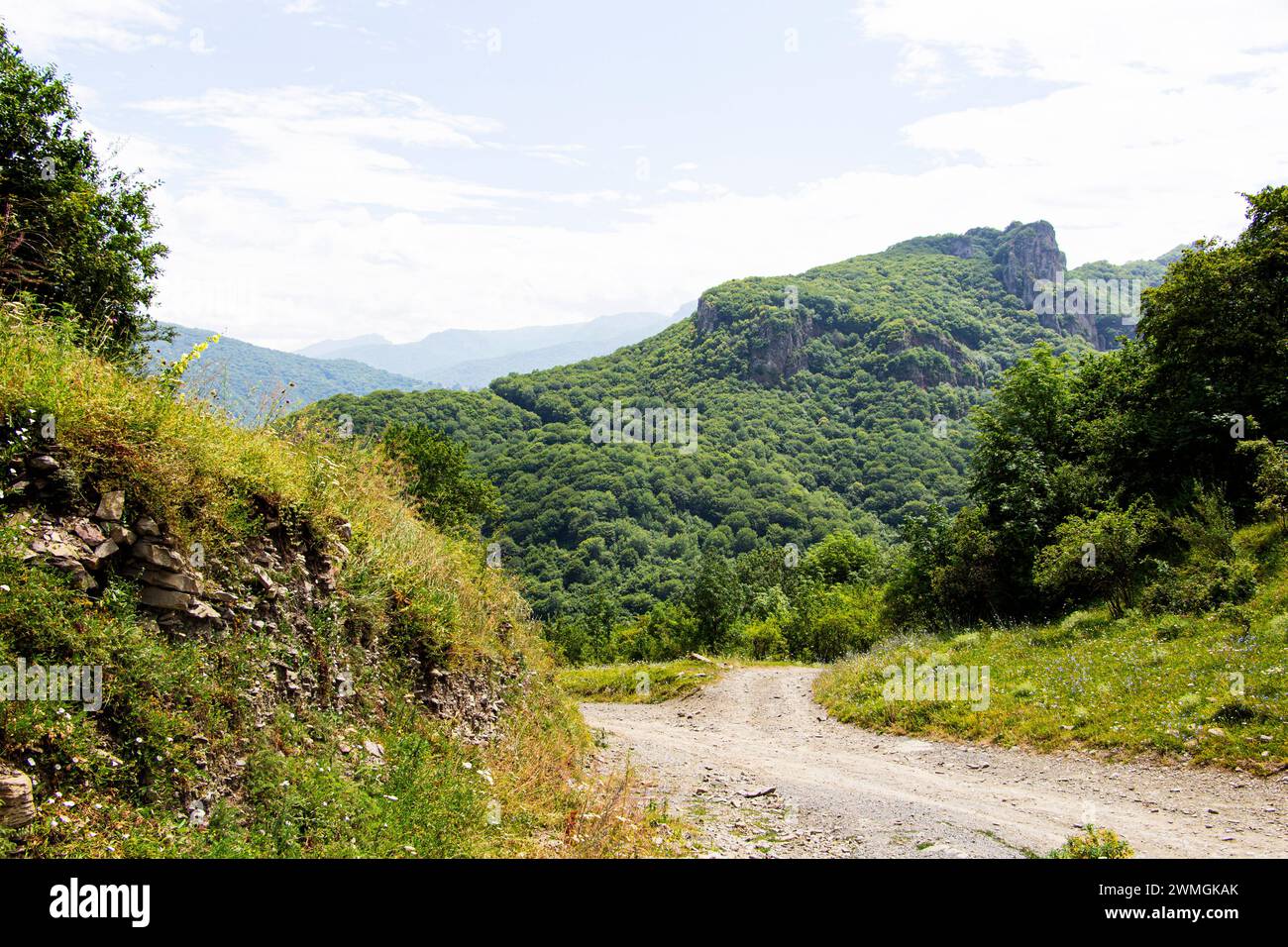Dirt road leading up into rough mountains Stock Photo - Alamy