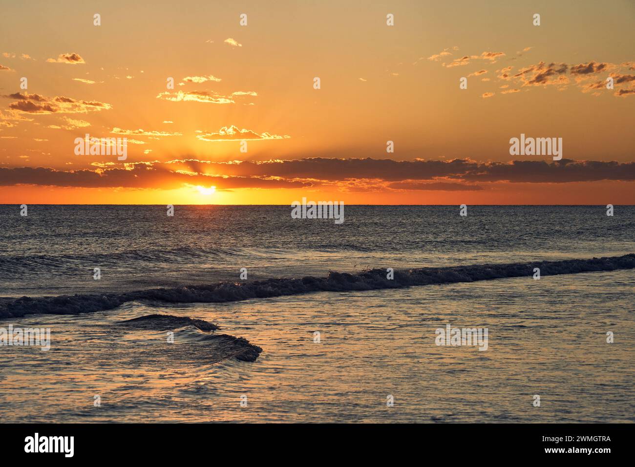 sunset at the beach. Sunset view from the beach with waves and blue sky ...