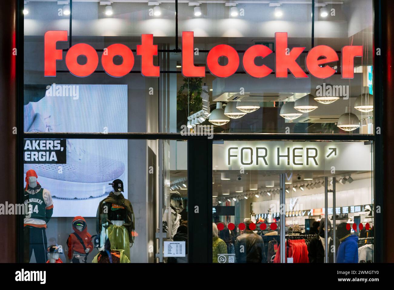 Through glass view of shopping people standing near products in ...