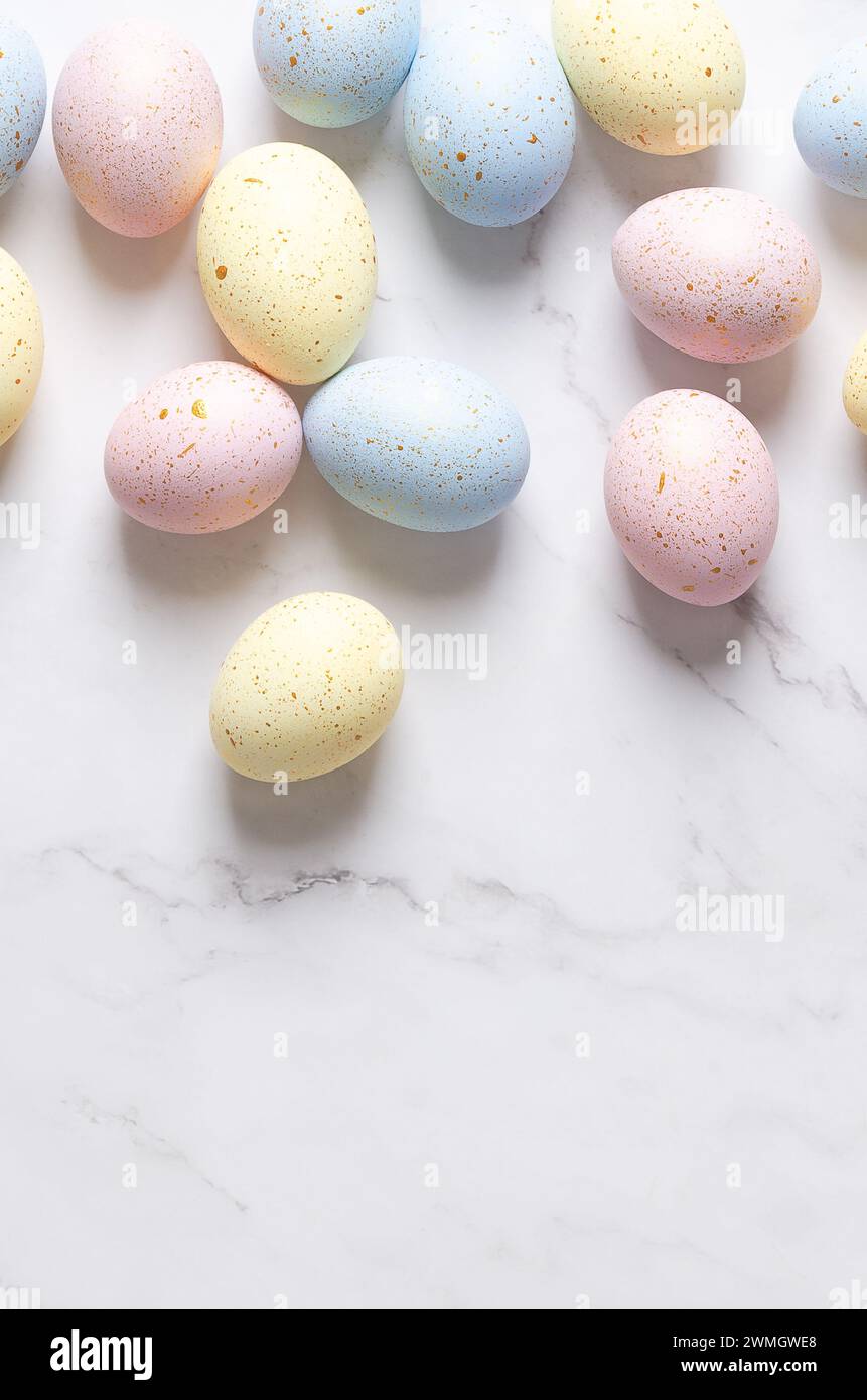 Easter background with pastel colored eggs with golden spots on a white ...