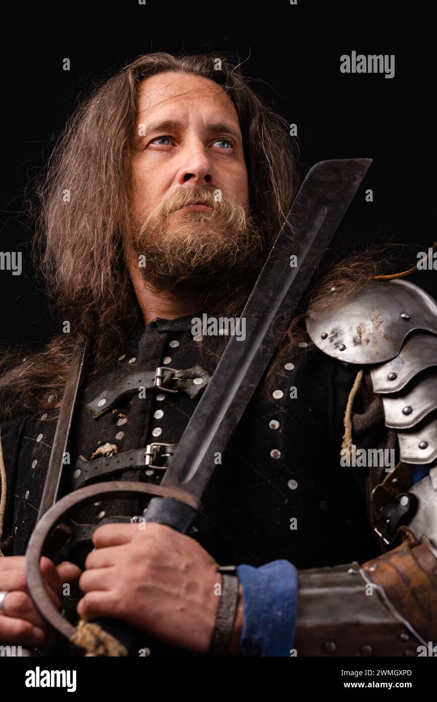 Vertical composition. Close-up portrait of a medieval knight with two ...