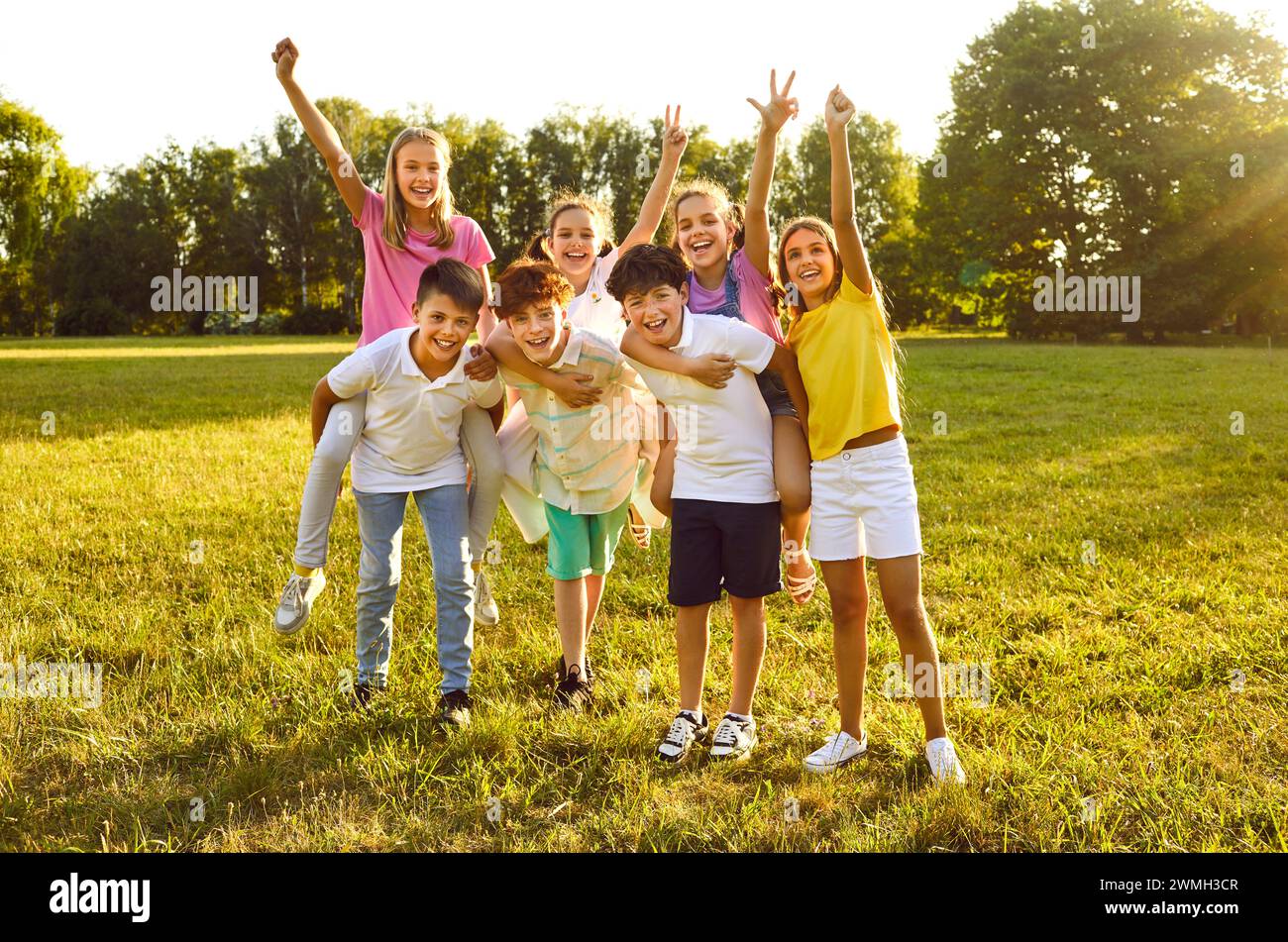 Happy children standing together outdoors and smiling in the park on ...