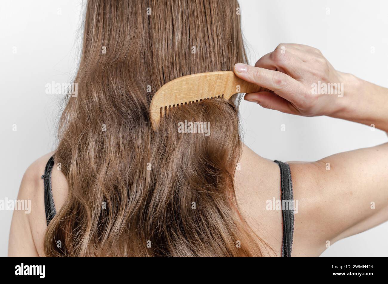 Close up of natural long hair. Woman combing her long hair with a comb ...