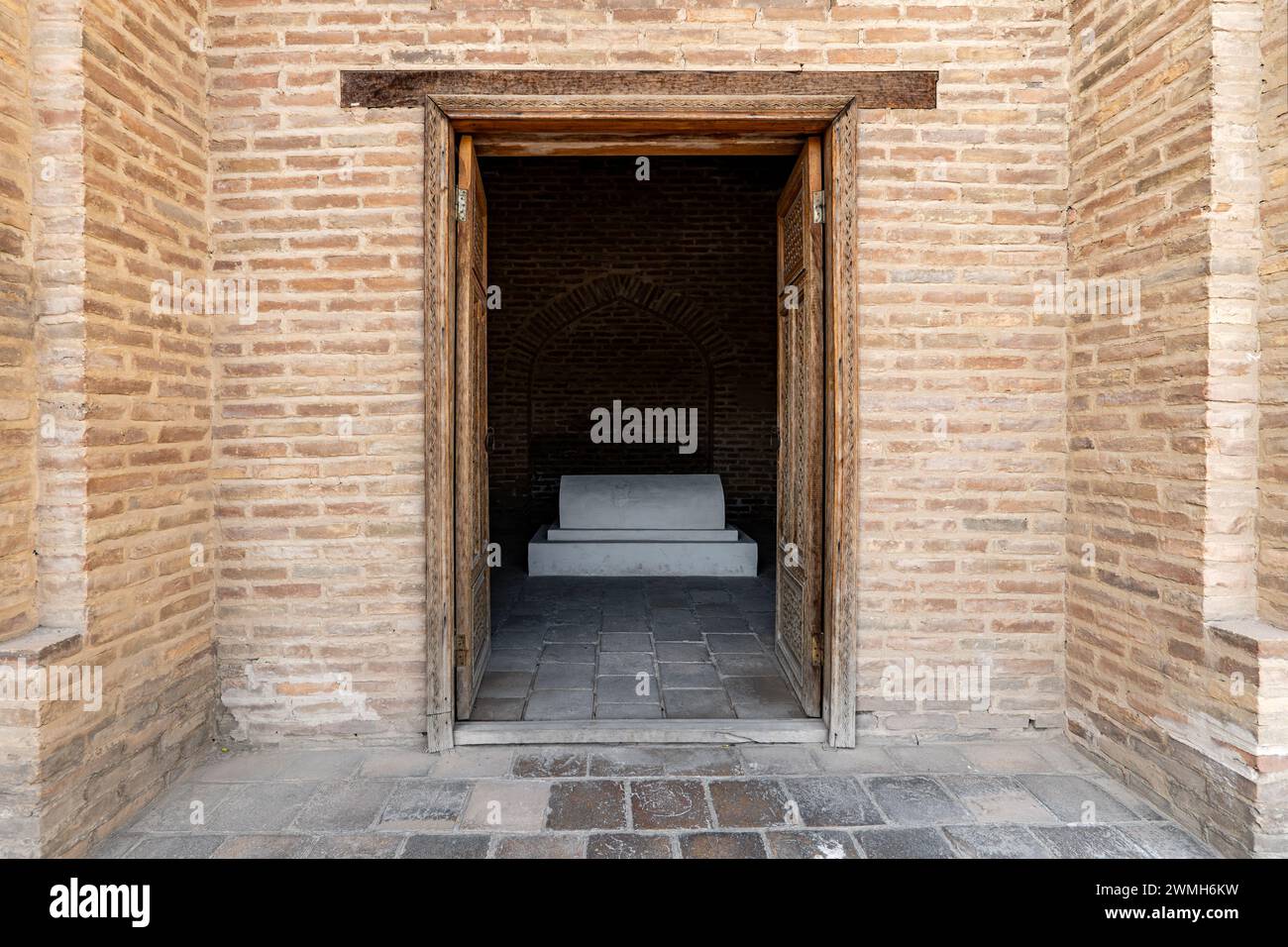 A white tombstone inside an ancient crypt in the old city of Samarkand ...
