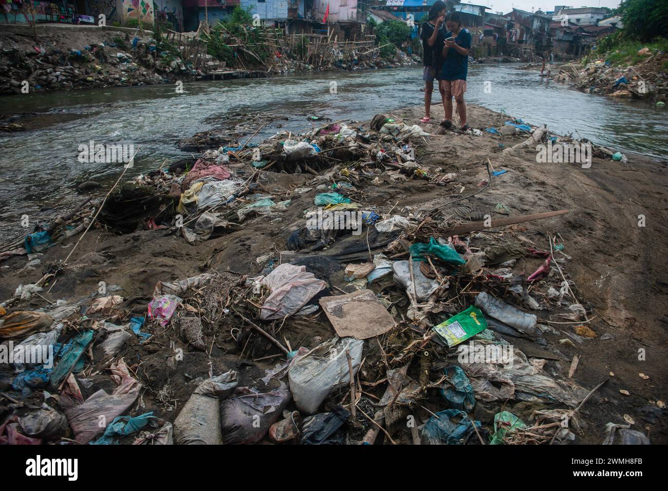 Two teenage girls pose with their cellphones in the Deli River which is ...