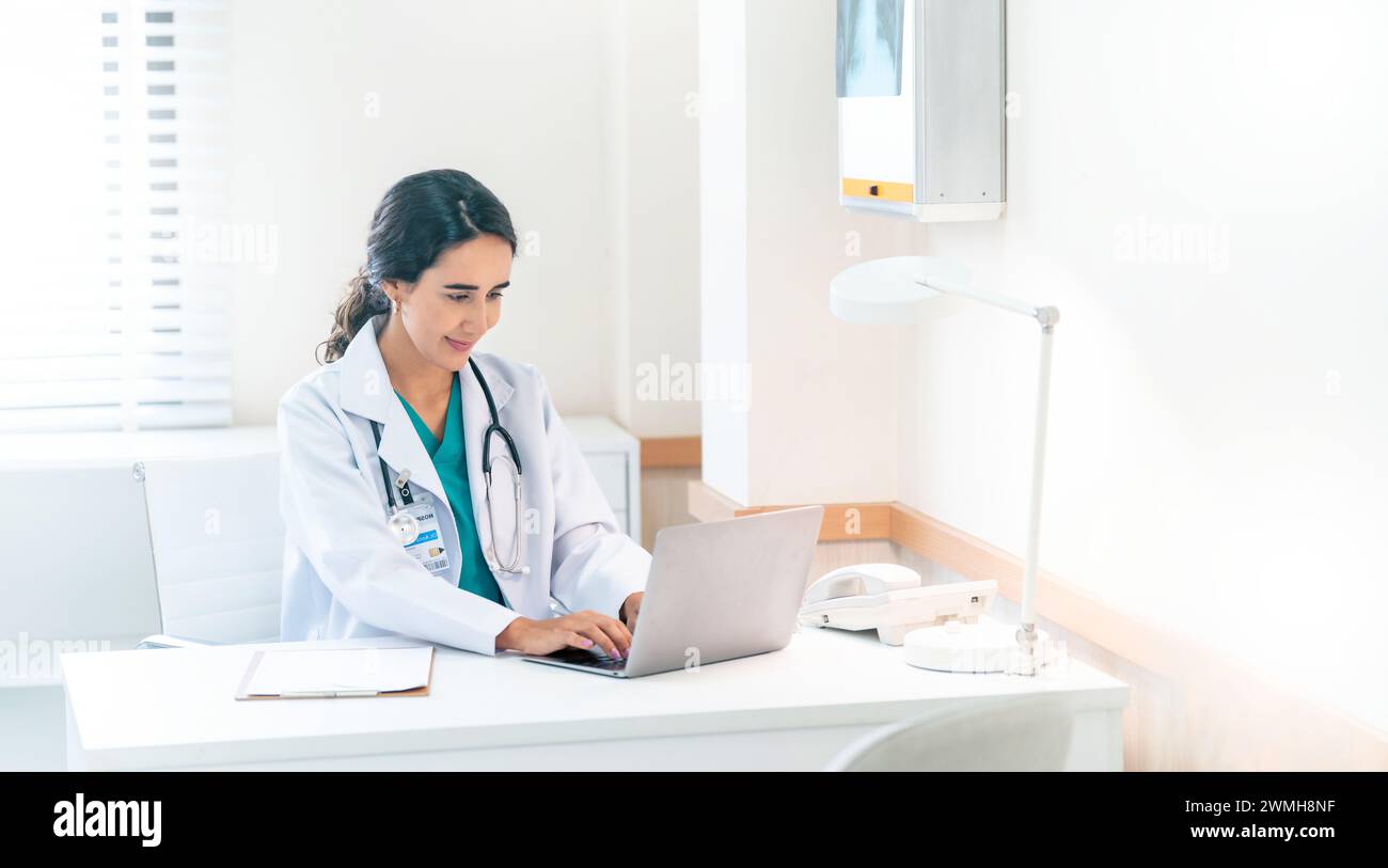 Beautiful and professional female doctor using laptop computer, working ...