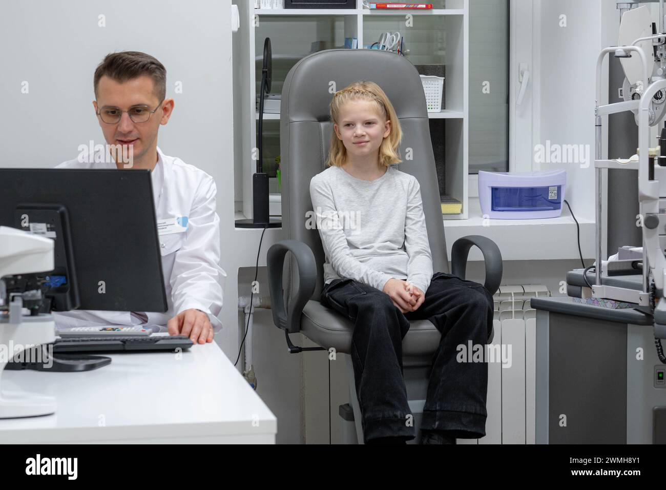 doctor and young patient in eye clinic, girl undergoing an eye test ...