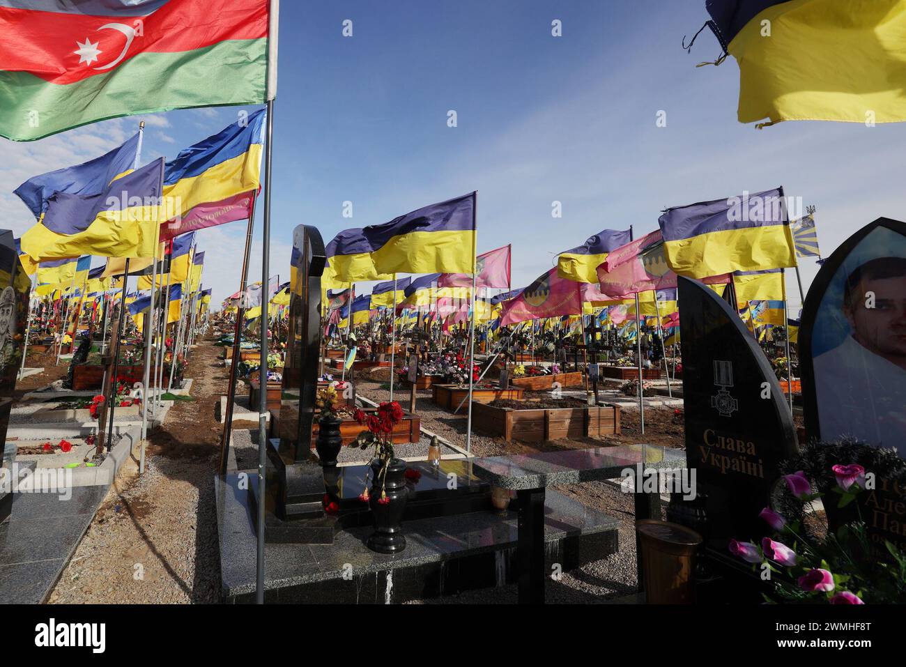 Charkiw, Ukraine. 26th Feb, 2024. Ukrainian flags fly over the graves ...