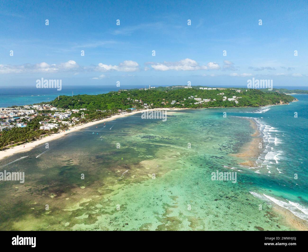 Drone view of white sand beaches with ocean waves and modern buildings ...