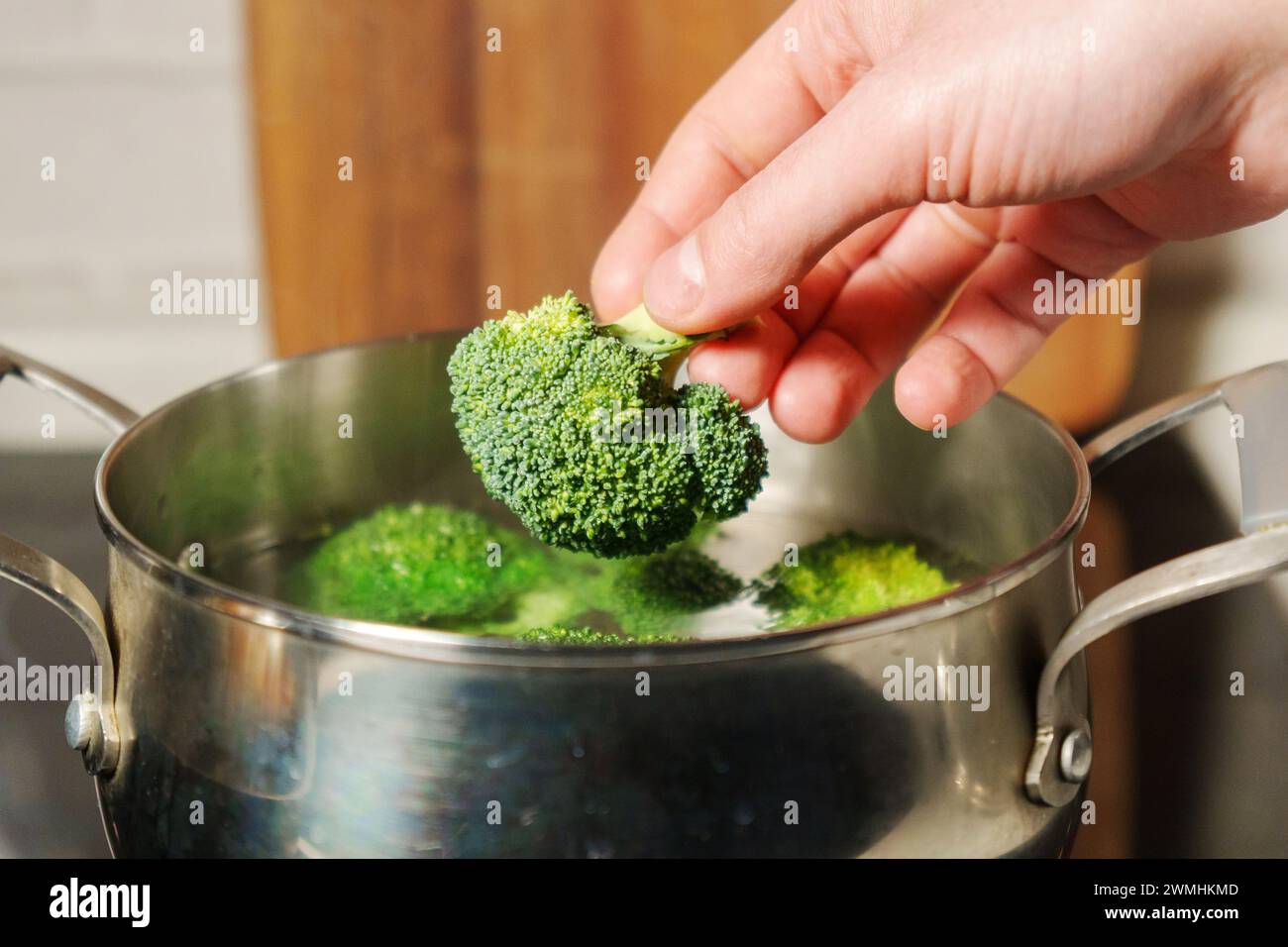 Vibrant broccoli to a bubbling pot of boiling water, creating a ...