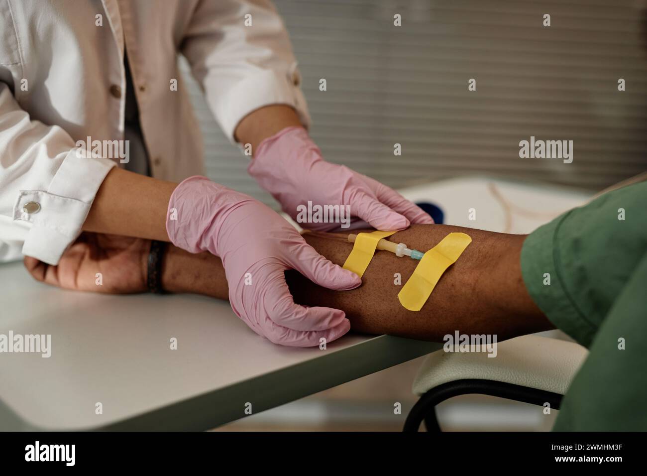Close up unrecognizable nurse preparing patient for IV drip treatment ...