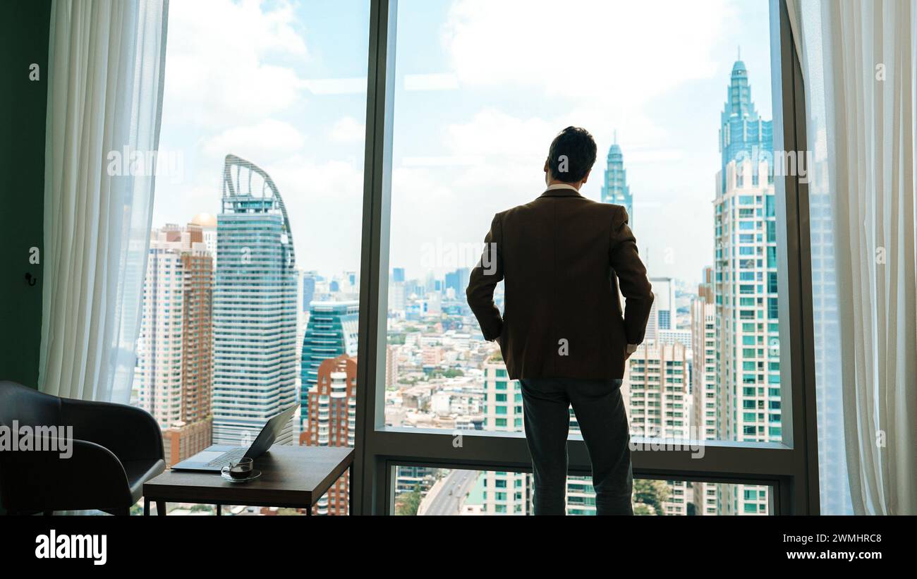 Back view ambitious businessman standing in ornamented office gazing ...