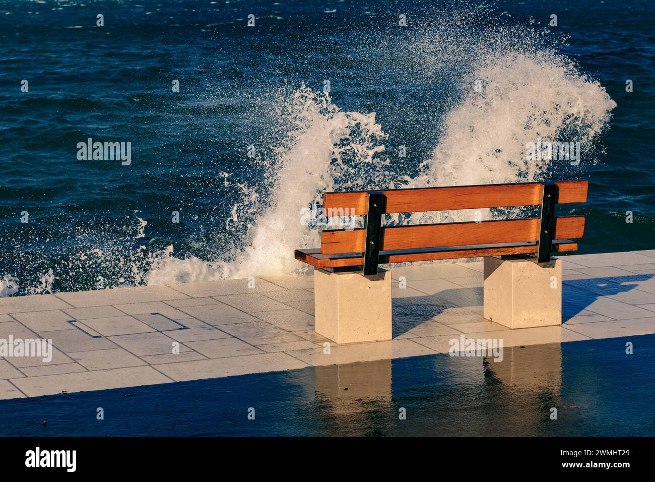 a bench by the wavy sea Stock Photo - Alamy