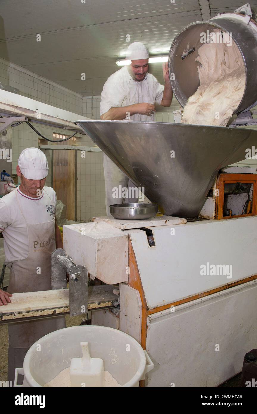 Operators adding flour into an industrial bakery machine Stock Photo ...