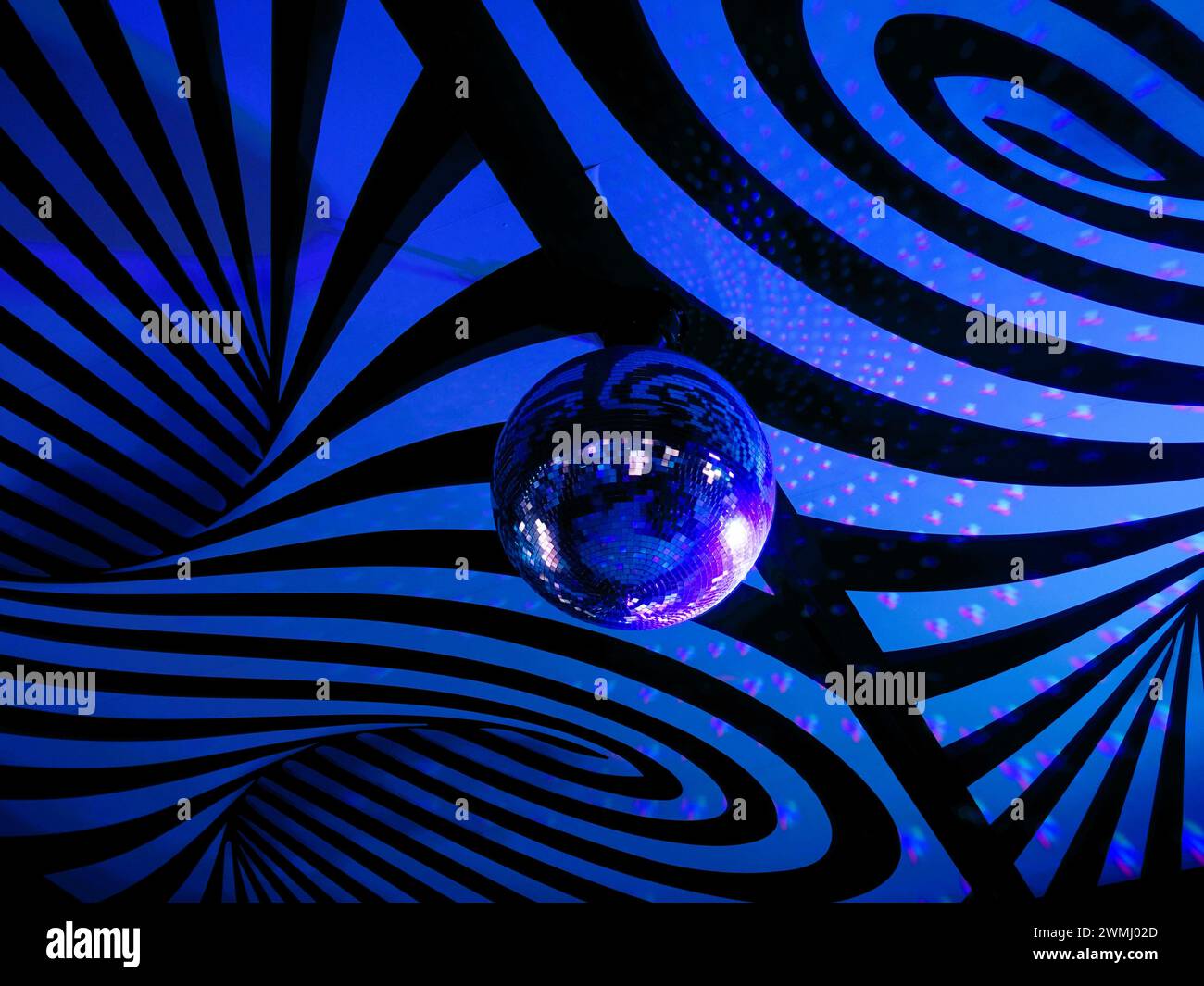 Glowing disco ball in monochrome room with blue lights Stock Photo - Alamy